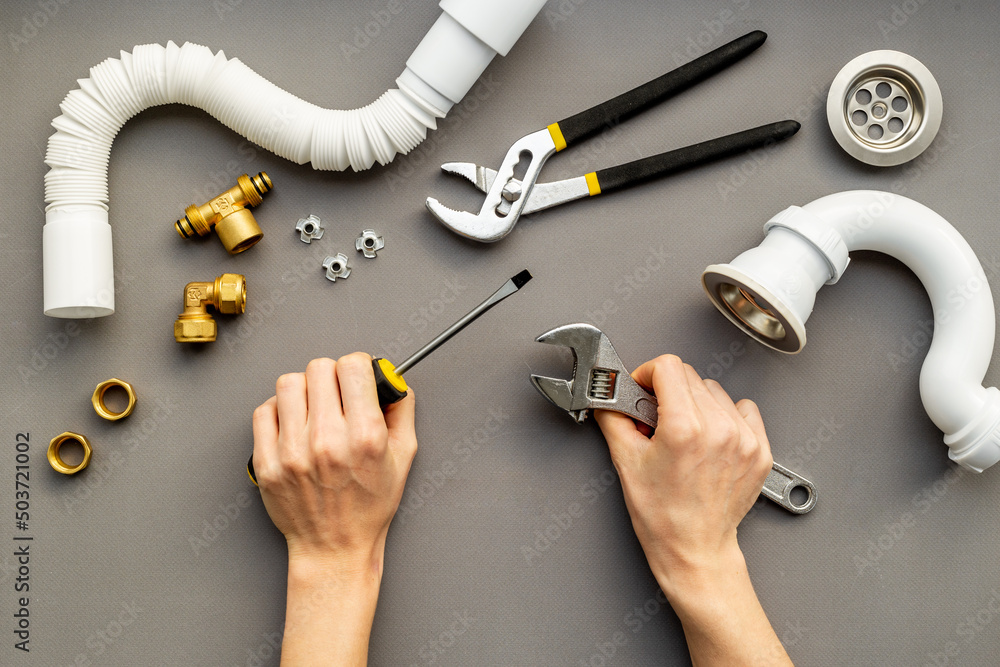 Hand with plumbing pipes and equipment. Plumbing work background Stock ...