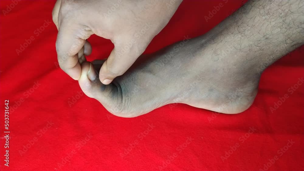 Physician, doctor or skin care professional hand massage bare foot ...