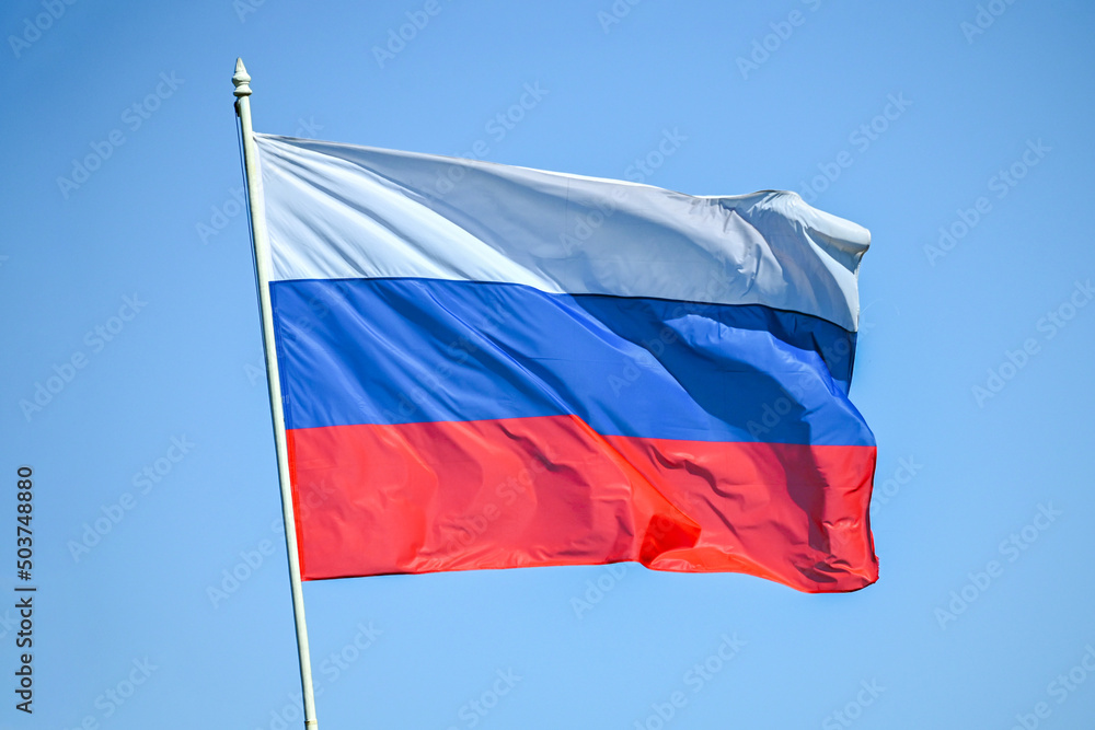 Flagpole with the Russian tricolor flag fluttering in the wind against ...