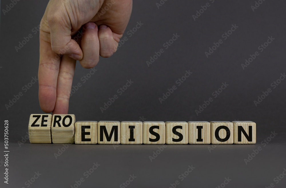 Zero emission symbol. Businessman turns wooden cubes and changes words ...