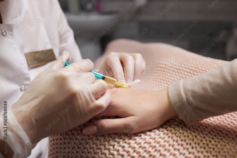 Doctor doing stem cell therapy on a patient's elbow after the injury ...