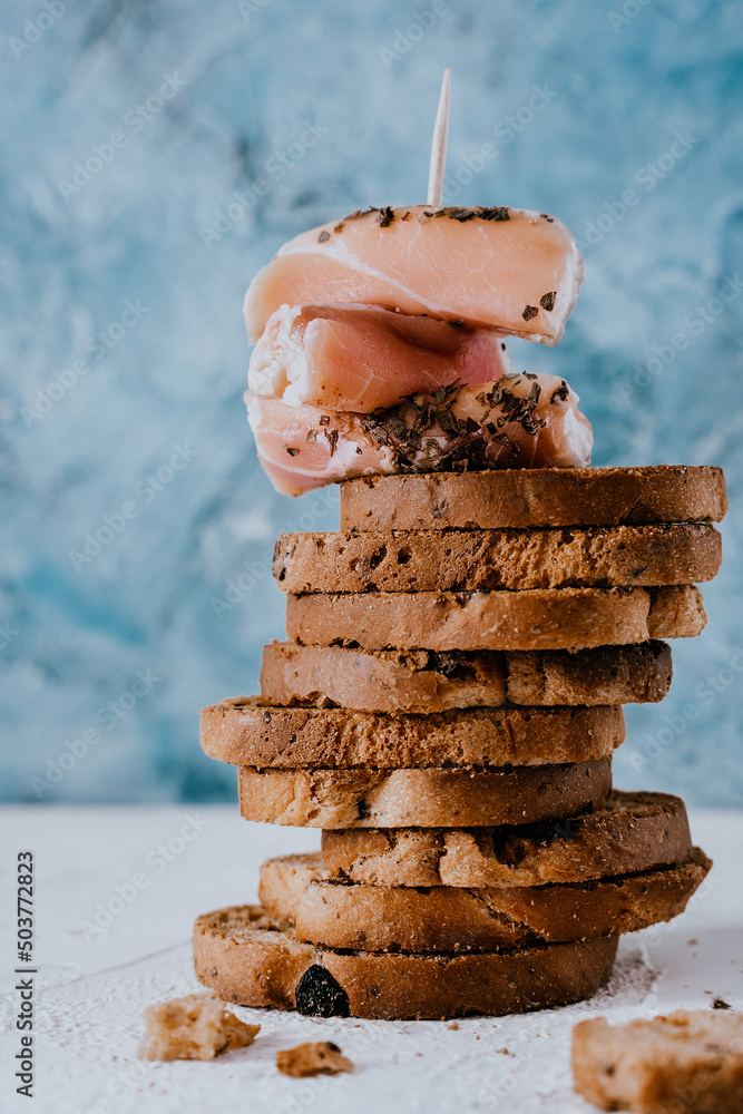 Food background. A tower of crispy toast with olives and ham and cream ...