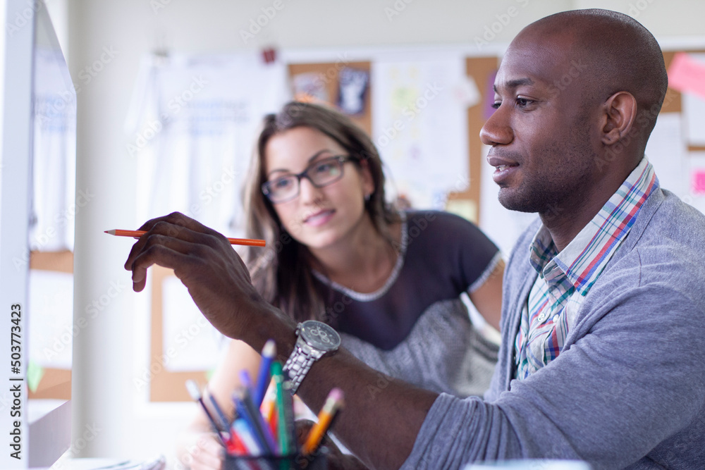 Foto de Coworkers reviewing work on a desktop computer do Stock | Adobe ...