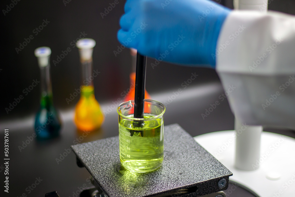 Measuring of pH of the solution using a digital pH meter. Woman in ...