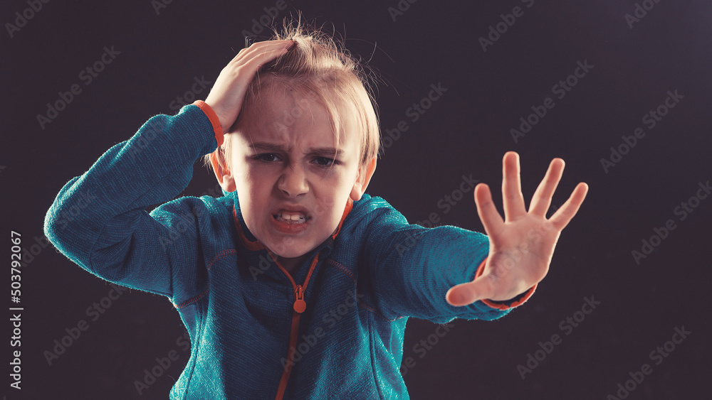 Unhappy boy over black background. Angry boy with a raised hand making ...