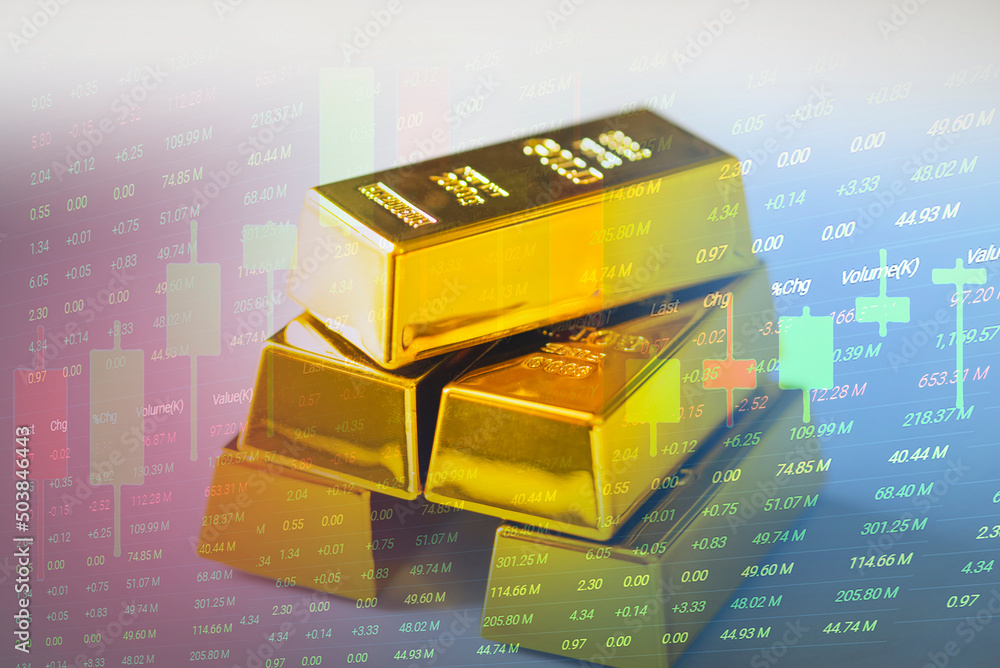 Gold trading, gold bars on fabric with stock graph chart stock market trade background, pile of ...