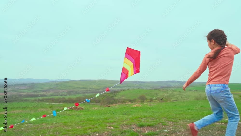 Video Stock Kid runs with a red kite. Happy little girl playing with ...