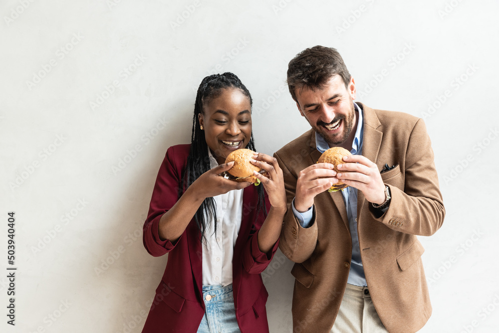 Young happy man and woman business people holding and eating fat tasty ...