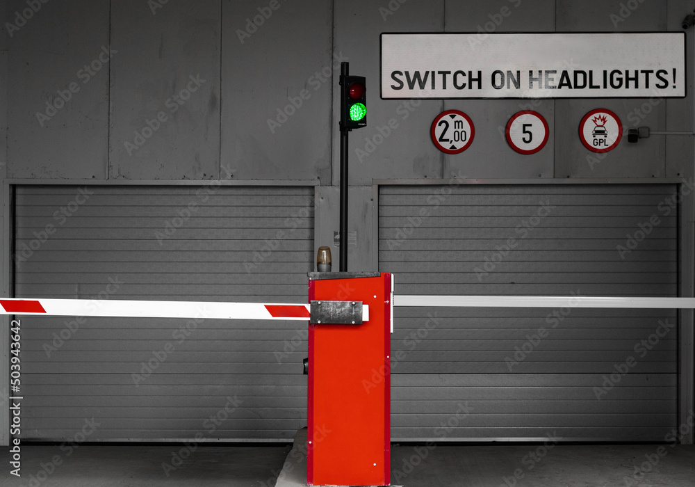 Subterranean parking garage entry gate with switch on headlights sign ...