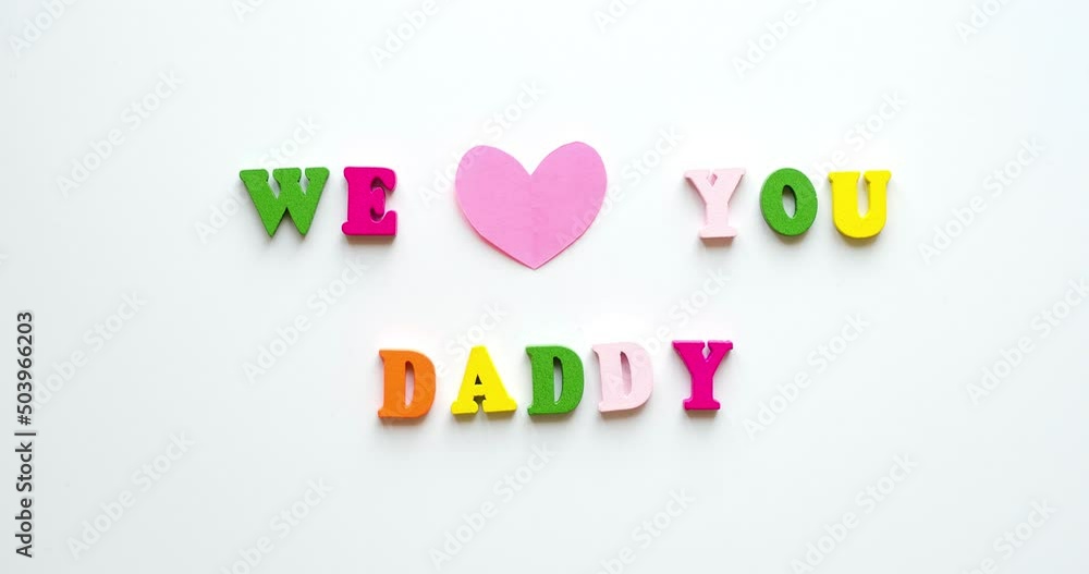 Phrase We Love You Daddy from colorful wooden letters and a beating ...