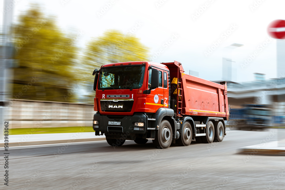 MAN TGS 41.440 tipper truck is driving in city on high speed. Dump ...