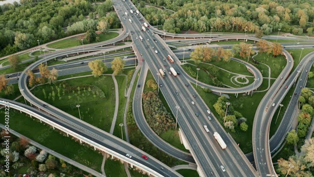 Aerial flyover car traffic roundabout interchange road in evening ...