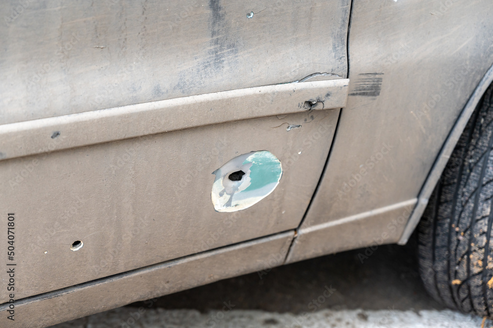 A car shelled during the war. Through holes from shrapnel and bullets ...