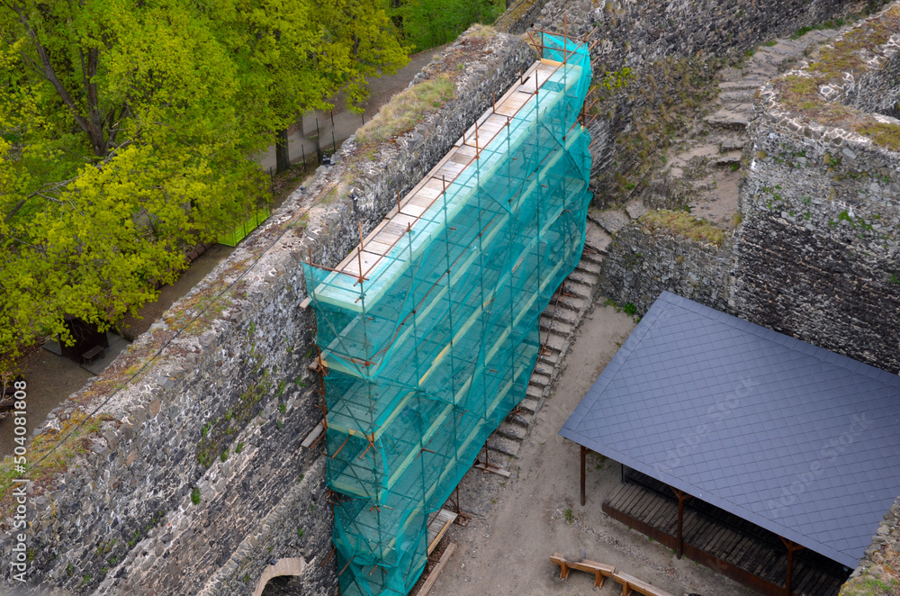 repair of the fortification wall of a medieval castle. net scaffolding ...
