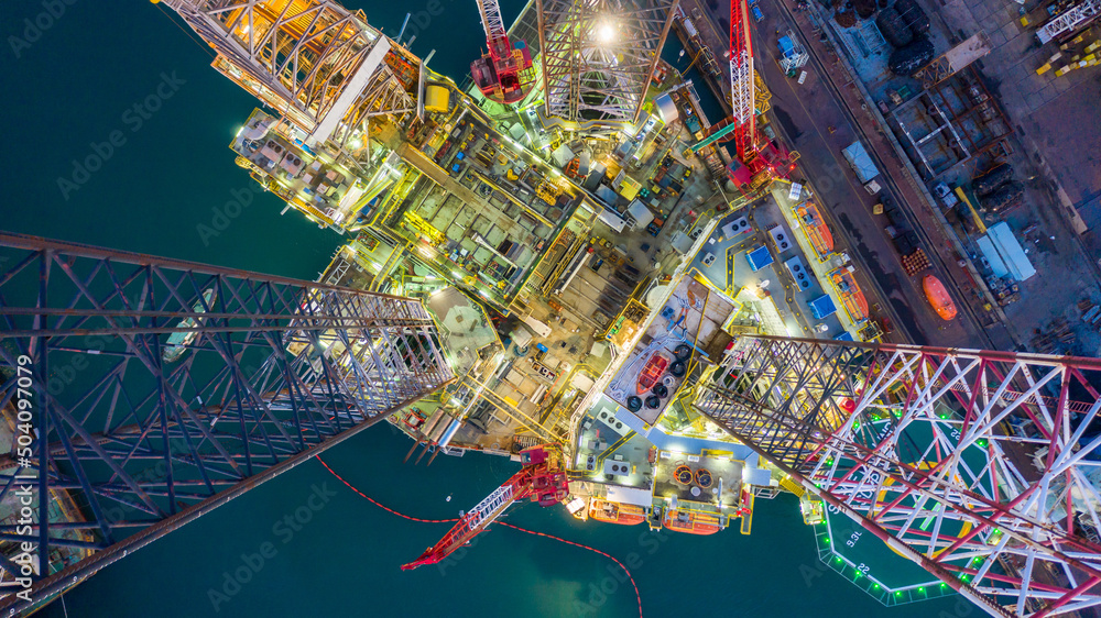 Aerial top view jack up rig under maintenance at night with blue ocean ...