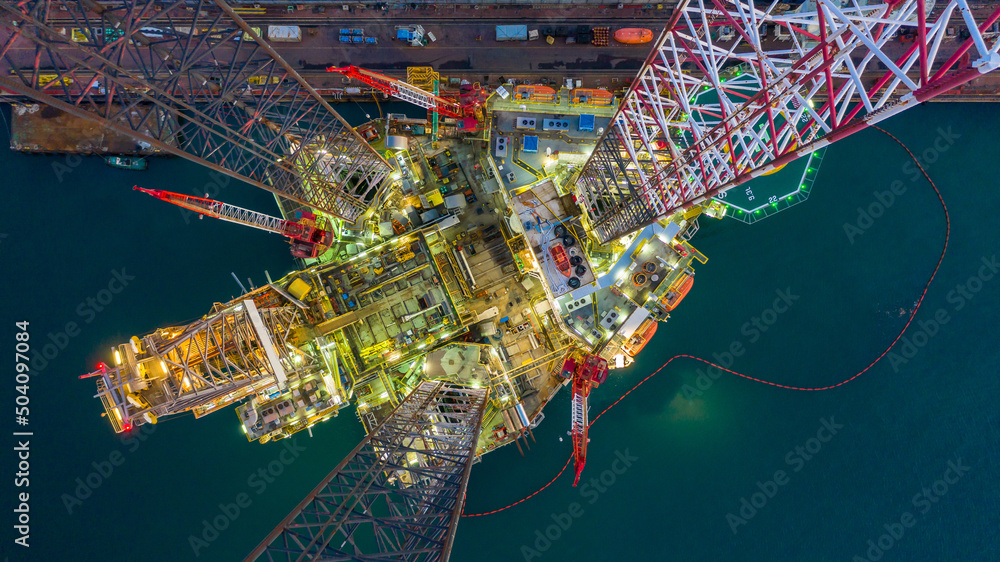 Aerial top view jack up rig under maintenance at night with blue ocean ...