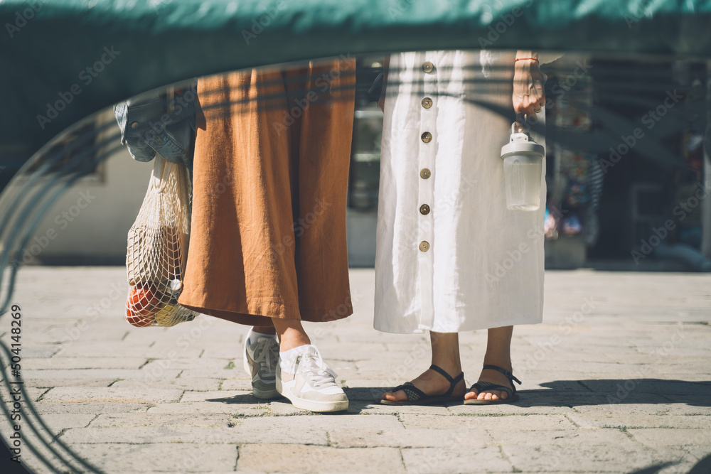 Young women shopping in flea market in Venice. Two girls in clothes ...