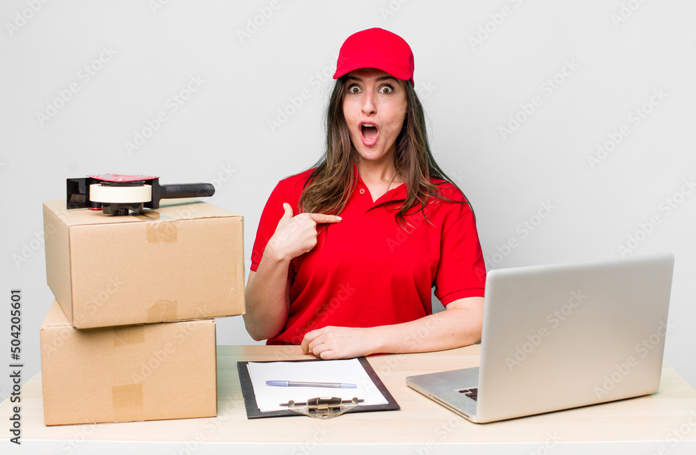 young pretty woman looking shocked and surprised with mouth wide open ...