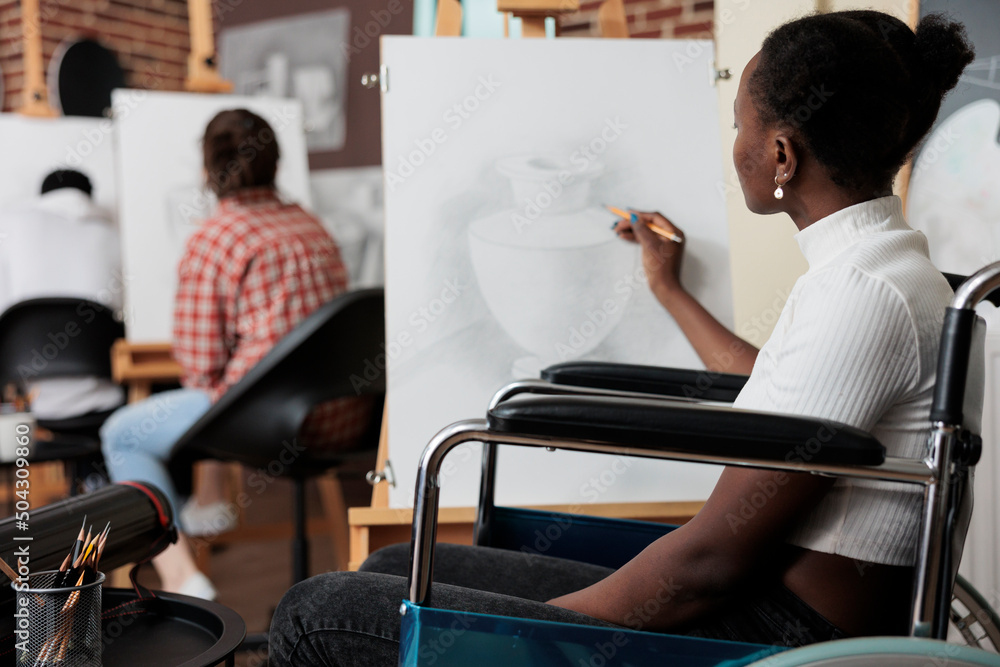 Paralyzed student in wheelchair attenting at artistic course drawing ...