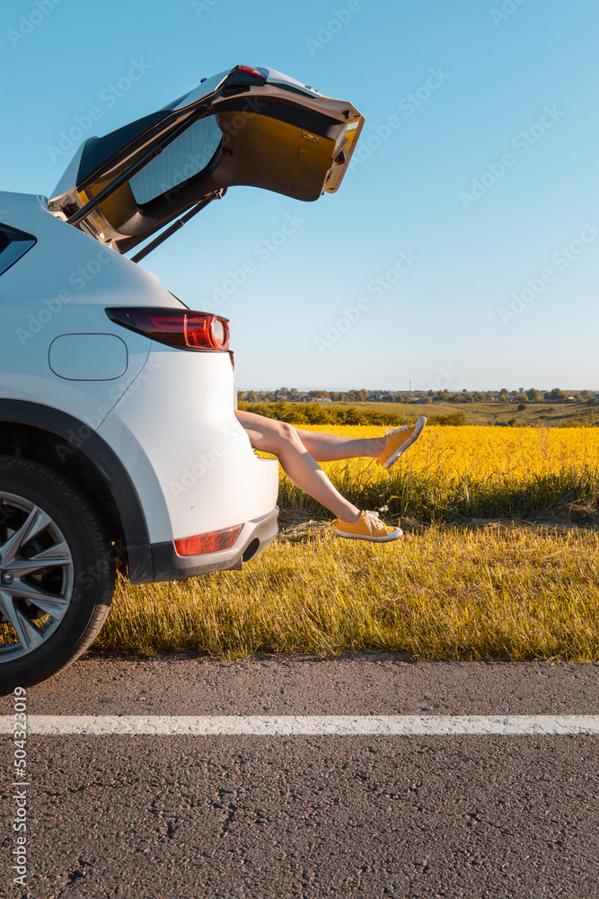 woman legs stick out of suv car trunk parked at roadside of speedway ...