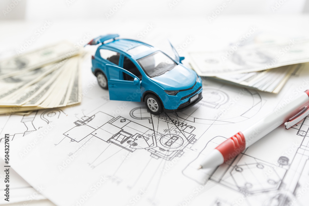 small car model and blueprint sheets. Stock Photo | Adobe Stock