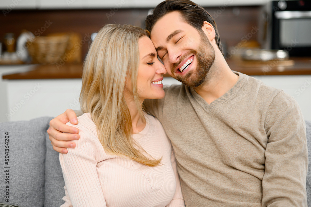 Gentle and lovely couple in love sitting in embrace on the comfortable ...