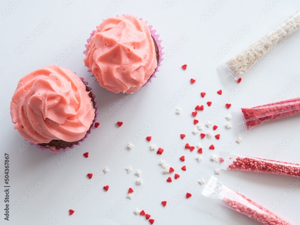 Cooking cupcake on white with a cap of pink cream and confectionery ...