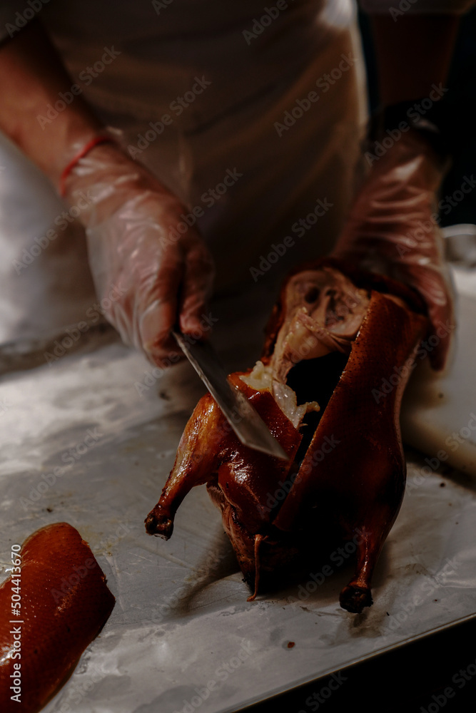 Chinese cook prepares Peking Roast Duck. Peking Duck is a famous duck ...