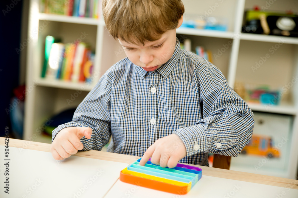 Child plays with sensory fidget toy Pop-it. Instrument for fine motoric ...