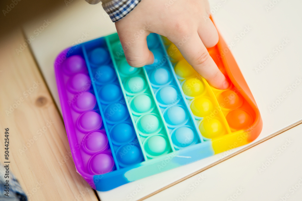 Child plays with sensory fidget toy Pop-it. Instrument for fine motoric ...