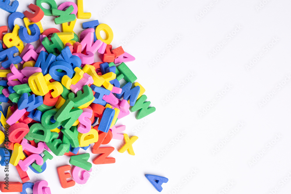 Group of colored letters stacked in a corner on a white background with ...