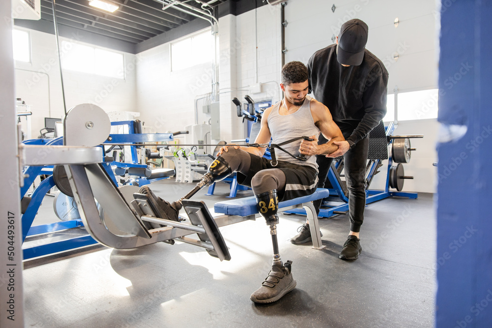 Trainer Helps Double Leg Amputee Workout Stock Photo | Adobe Stock
