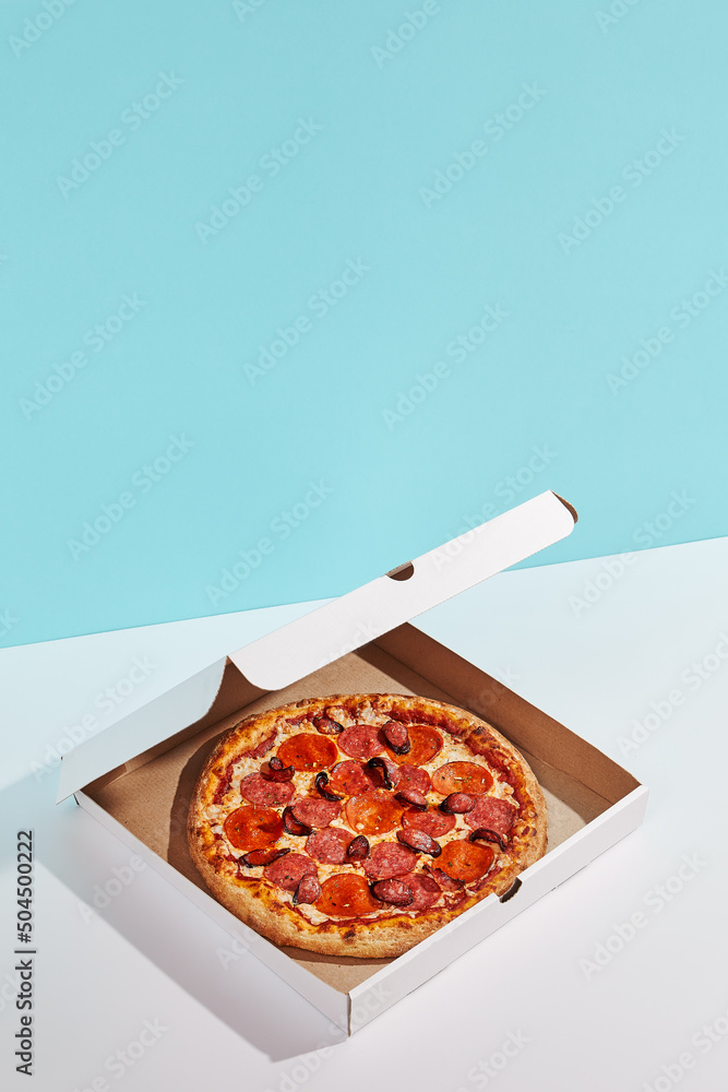 Italian pizza in paper box on coloured background. Meat pizza with ...
