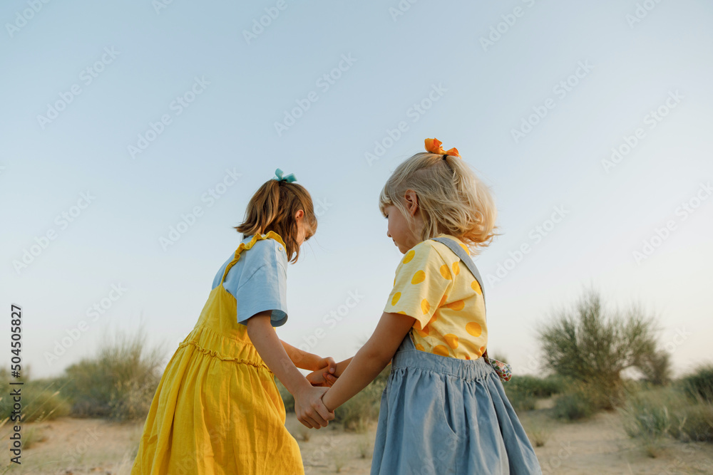 Kids holding hands outdoors Stock Photo | Adobe Stock