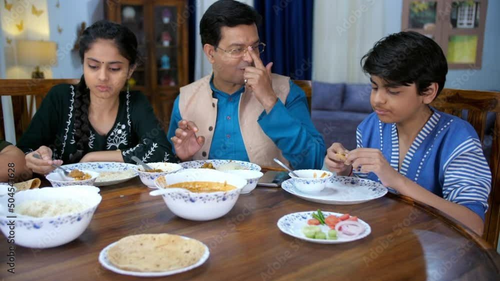 A Bengali family - Father and kids having food at the dining table ...