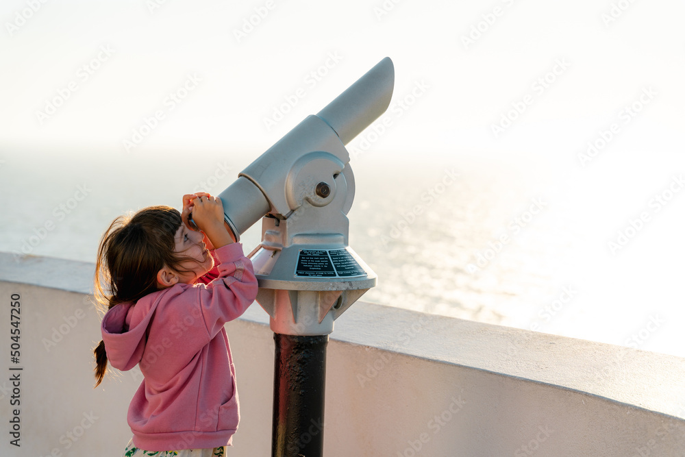 Little girl looking with monocular Stock Photo | Adobe Stock