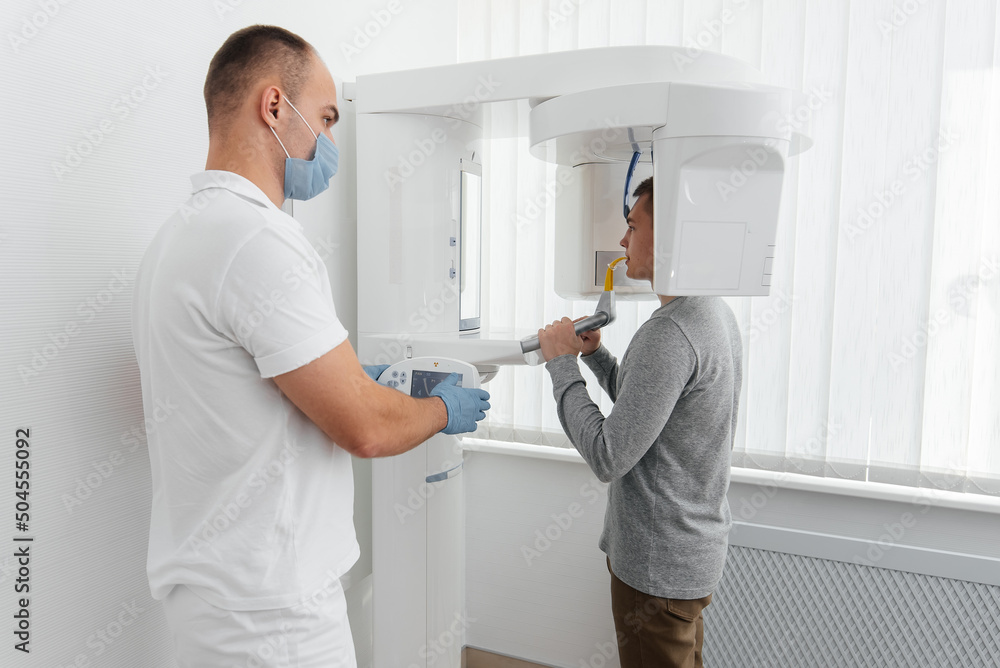 A young man has a computed tomography of the jaw, a circular snapshot ...