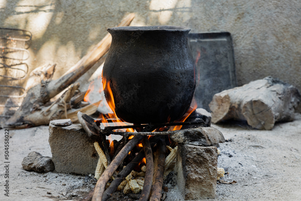 Black clay pot on a traditional stove with high fire Stock Photo ...