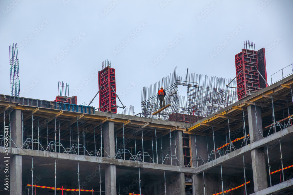 A worker prepares formwork for a modern metal-concrete structure of a ...