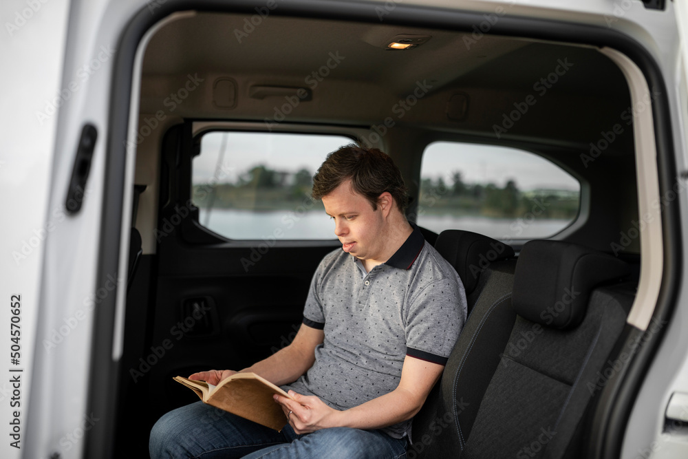 Man with down syndrome reading a book Stock Photo | Adobe Stock