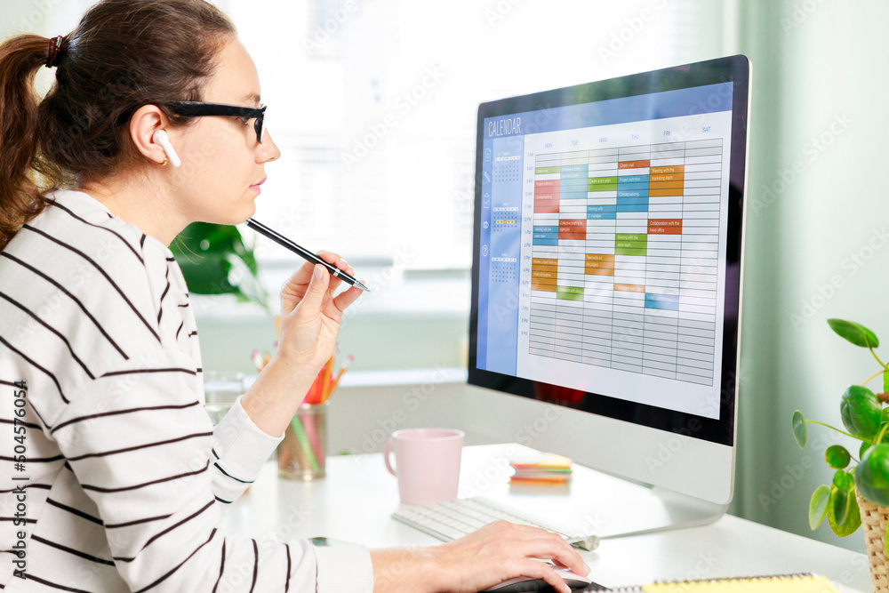 Foto de Freelancer business woman using calendar on computer to improve ...