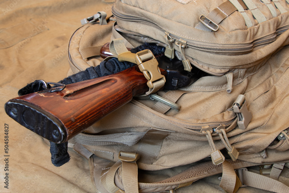Military green backpack with a machine gun on a green background ...