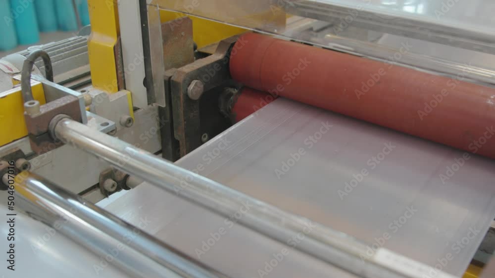 Plastic cast film gradually moves along cast film extrusion machine ...