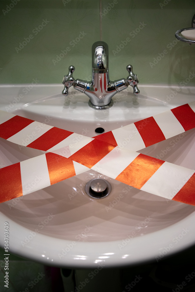 The sink is covered with a red ribbon.It is forbidden to use the sink ...