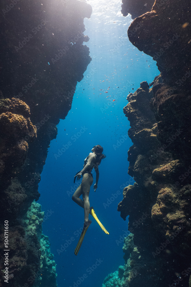 Woman freediver posing over sandy bottom with yellow fins. Freediving ...