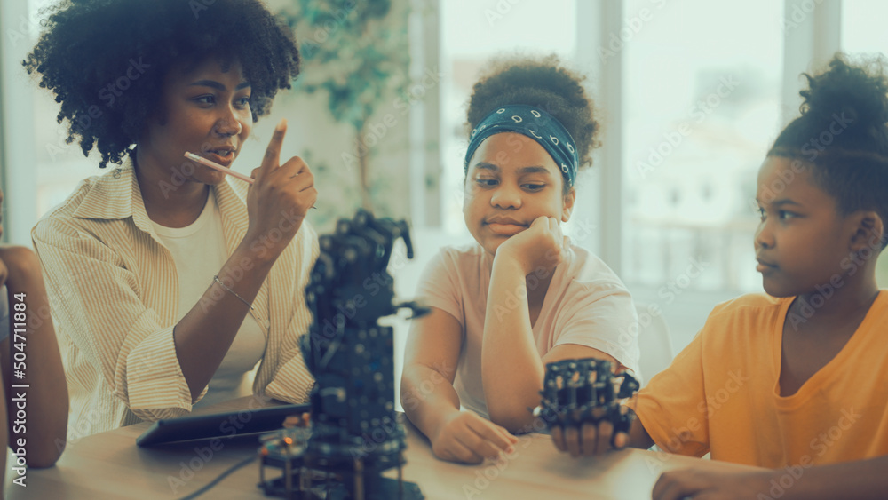 Child controlling Robotic arm in high school. Stock Photo | Adobe Stock Child controlling Robotic arm in high school. Stock Photo | Adobe Stock