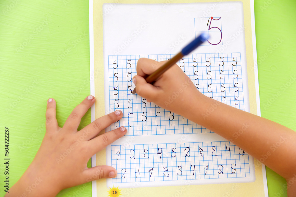Hand of child holding pencil and study with learning writing number on ...