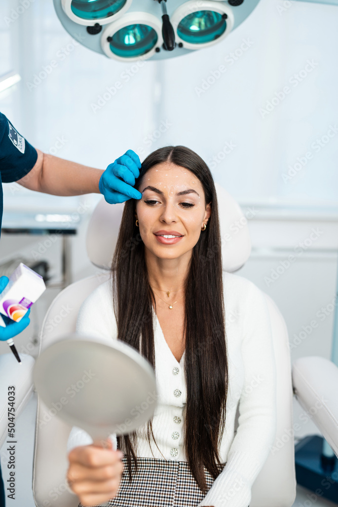 Beautiful and happy brunette woman at beauty medical clinic. She is ...