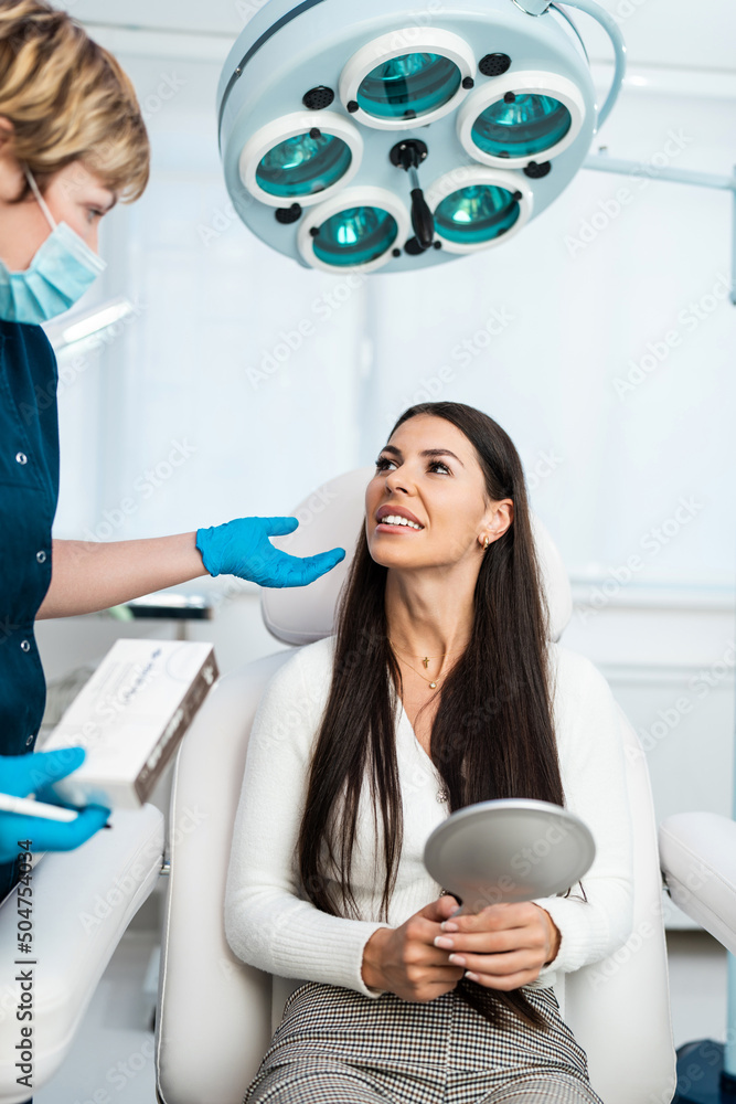 Beautiful and happy brunette woman at beauty medical clinic. She is ...