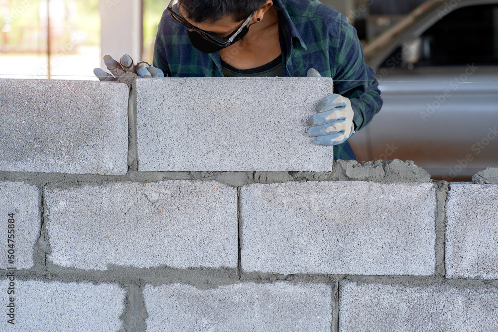 masonry worker make concrete wall by cement block and plaster at ...